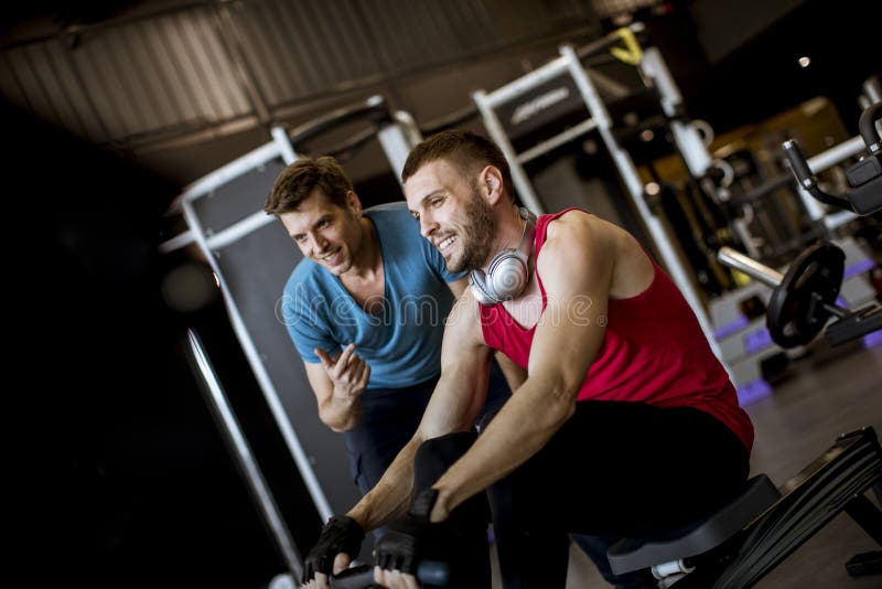 Young Man with Trainer Doing Exercise in the Gym Stock Photo - Image of ...