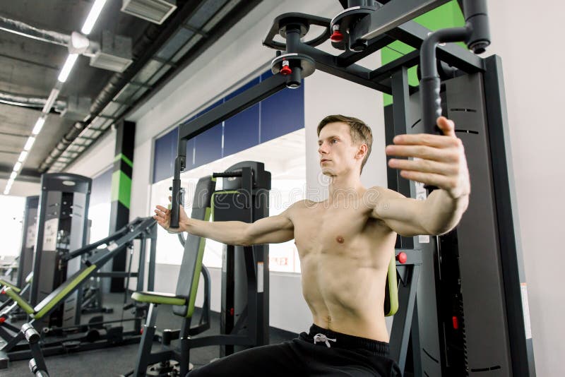 Young Man Training in the Gym. Ripped Bodybuilder Working Out in Gym ...