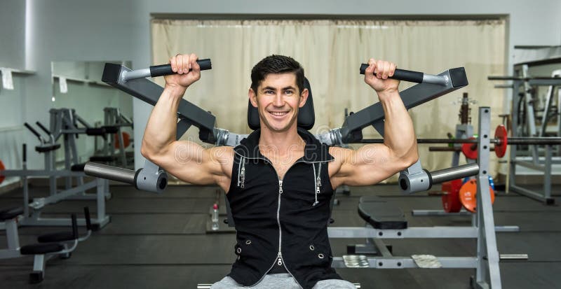 Young Man Training at Sportive Equipment in Gym Stock Photo - Image of ...