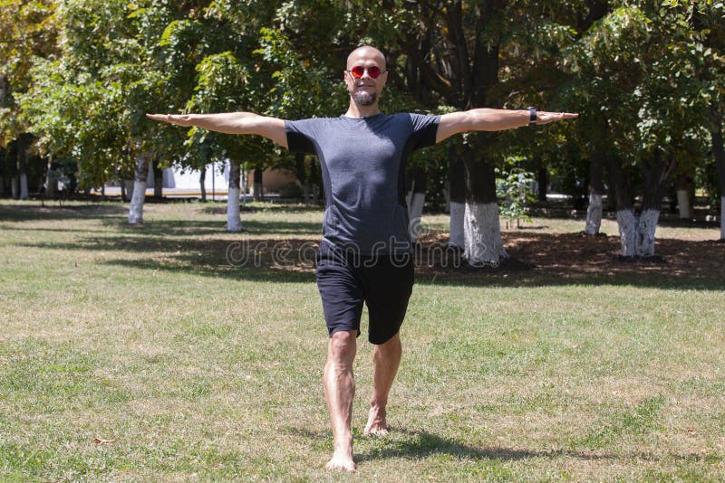 Young Man Training Yoga Outdoors Sporty Guy Makes Stretching Exercise