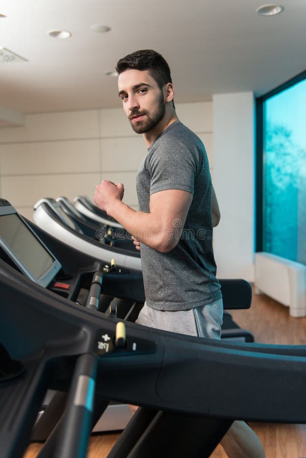 Young Man on Treadmill stock image. Image of muscular - 71101315