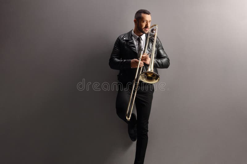 Young Man with a Trombone Standing and Leaning on a Wall Stock Photo ...