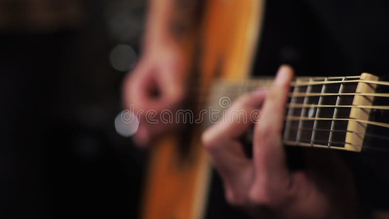 A Young Man Tunes an Acoustic Guitar Plucking the Strings and Musical ...