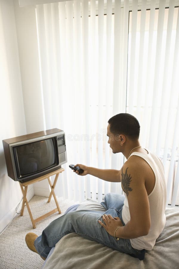 Young Man Turning on TV stock image. Image of indoors - 12968587