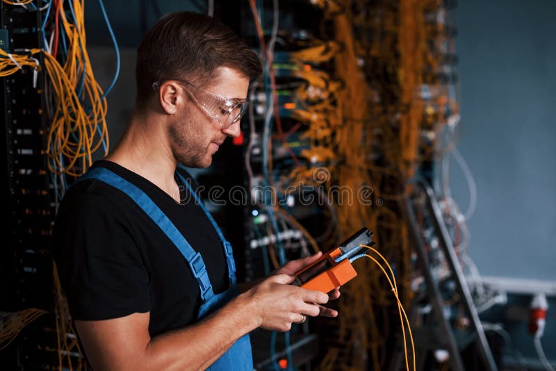 Young Man in Uniform with Measuring Device Works with Internet ...