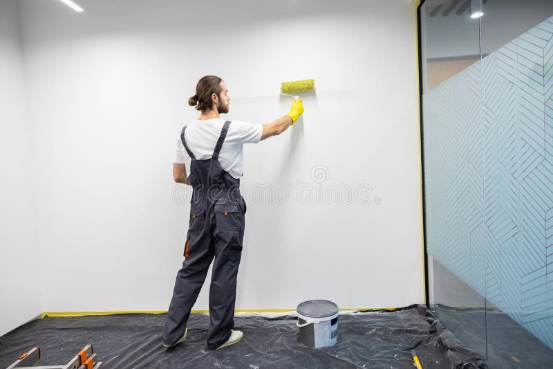 Young Man in Uniform Painting the Wall and Looking Busy Stock Photo - Image of adult, roller ...