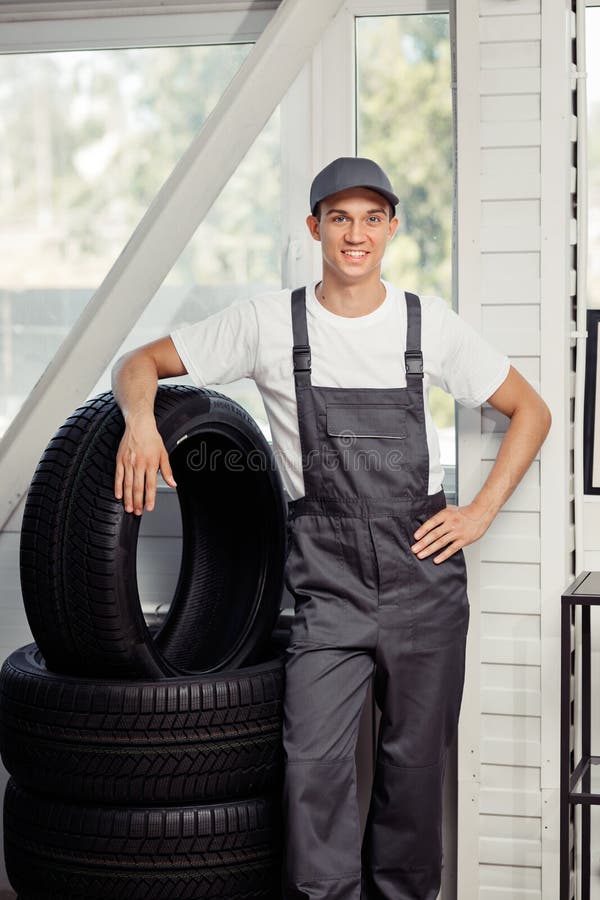 A Young Man in Uniform is Standing Near Tires Stock Photo - Image of ...