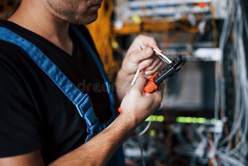 Young Man in Uniform Works with Internet Equipment and Wires in Server ...