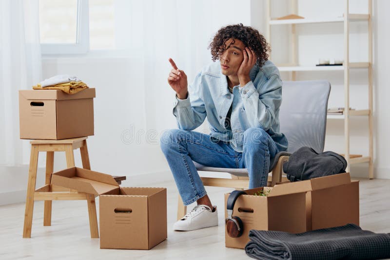 A Young Man Unpacking Things from Boxes in the Room Interior Stock ...