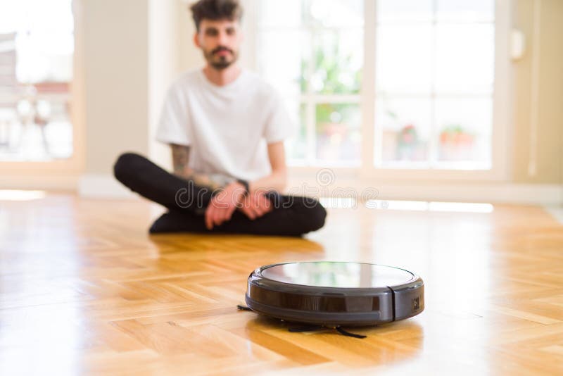 Young Man Using Automatic Vacuum Cleaner To Clean the Floor, Controling ...