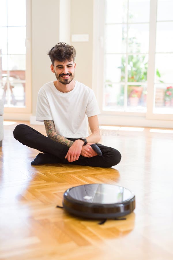 Young Man Using Automatic Vacuum Cleaner To Clean the Floor, Controling ...