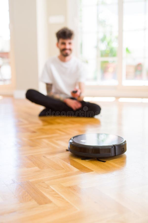 Young Man Using Automatic Vacuum Cleaner To Clean the Floor, Controling ...