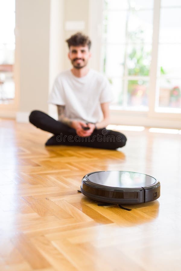 Young Man Using Automatic Vacuum Cleaner To Clean the Floor, Controling ...