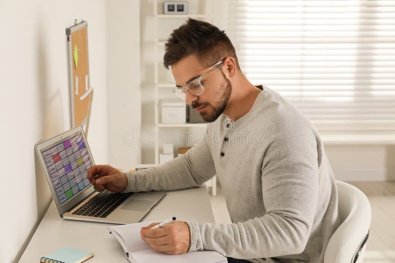 Young Man Using Calendar App on Laptop Stock Image - Image of glasses ...