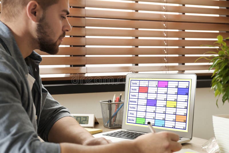 Young Man Using Calendar App on Laptop in Office Stock Photo - Image of ...