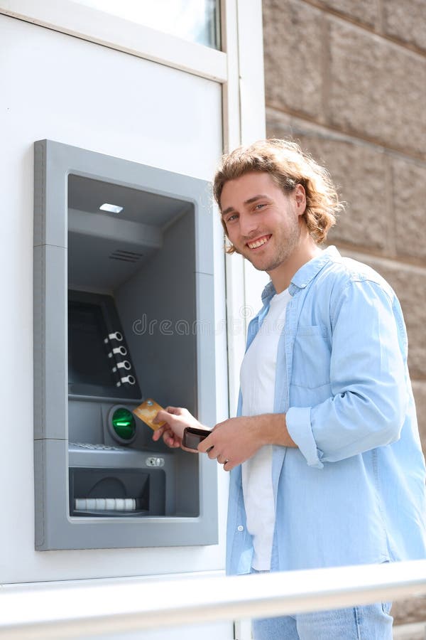 Young Man Using Cash Machine for Money Withdrawal Stock Image - Image ...