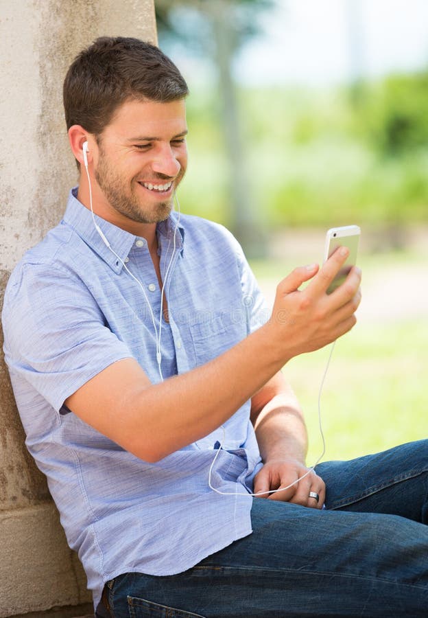 Young man using cell phone stock image. Image of outside - 42018549