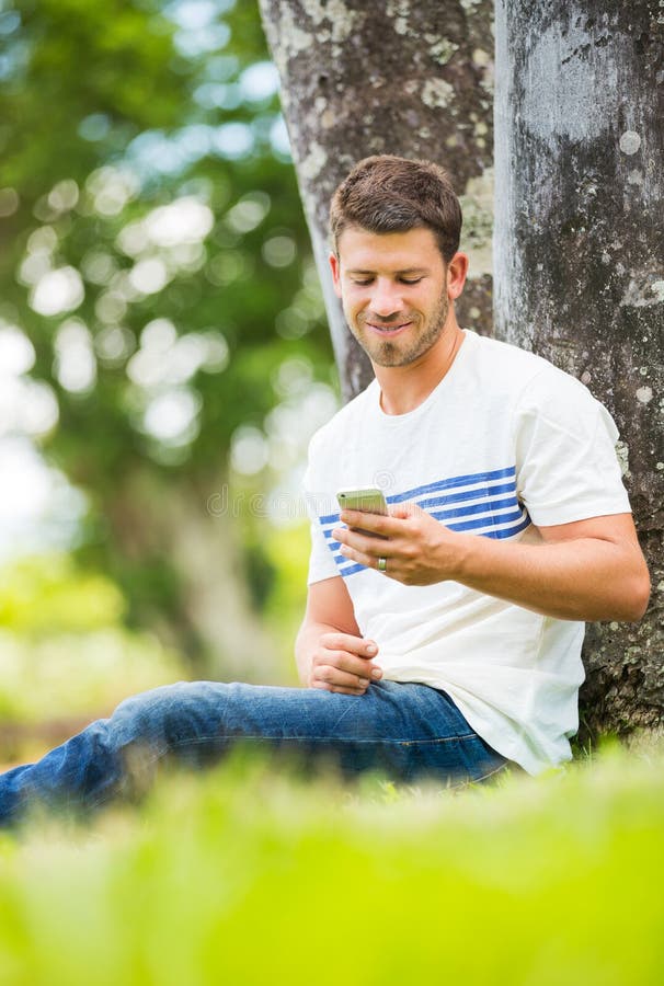 Young man using cell phone stock image. Image of outside - 42018549
