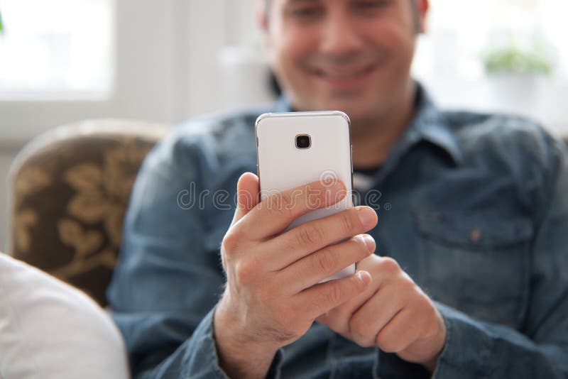 Young man using cell phone stock photo. Image of indoors - 73592294