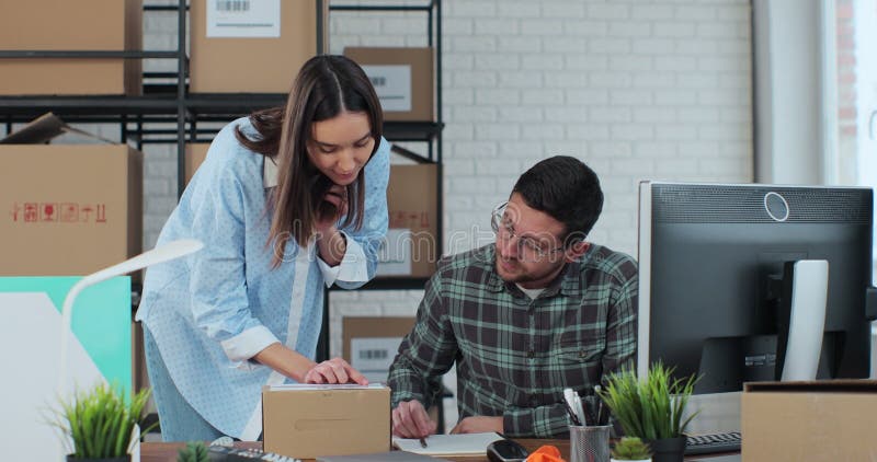 A Young Man Using a Computer, a Woman Confirms the Contact Details on ...