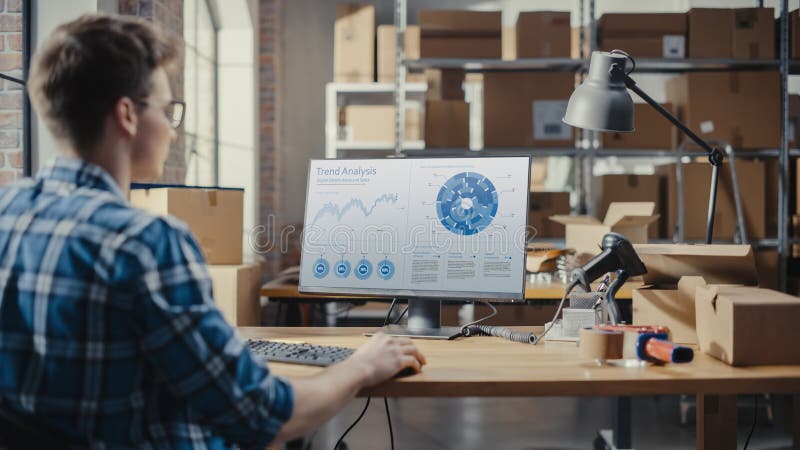 Young Man Using Desktop Computer with a Trend Analysis Charts Display ...