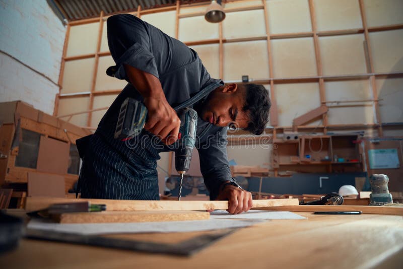 Young Man Using Drill on Wood during Work at Woodworking Factory Stock ...