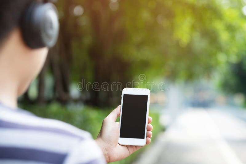 Young Man Using Earphone Mobile Smart Phone. Stock Image - Image of ...