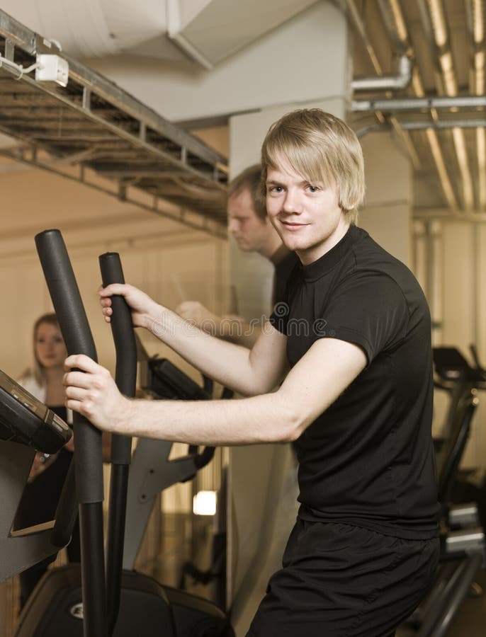 Young Man Using an Exercise Machine Stock Image - Image of flexing ...