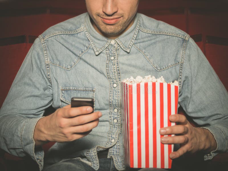 Young Man Using His Phone at the Cinema Stock Photo - Image of ...