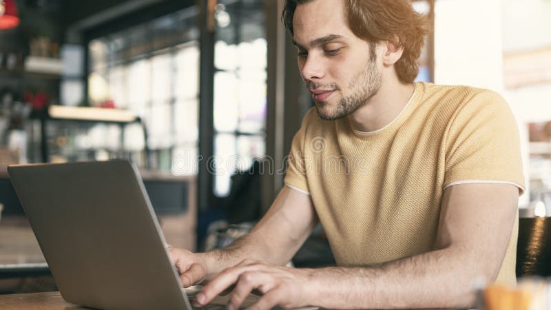 Young Man Using Laptop Computer in Cafe Stock Photo - Image of male ...
