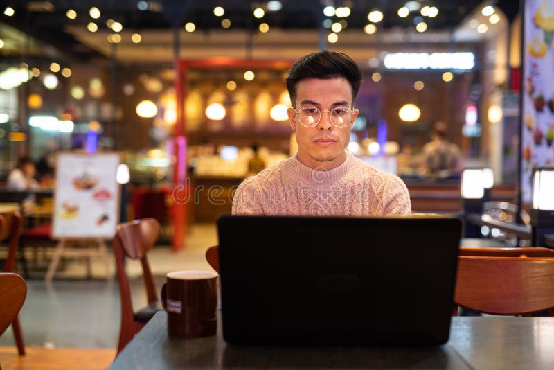 Young Man Using Laptop Computer at Coffee Shop Stock Image - Image of ...