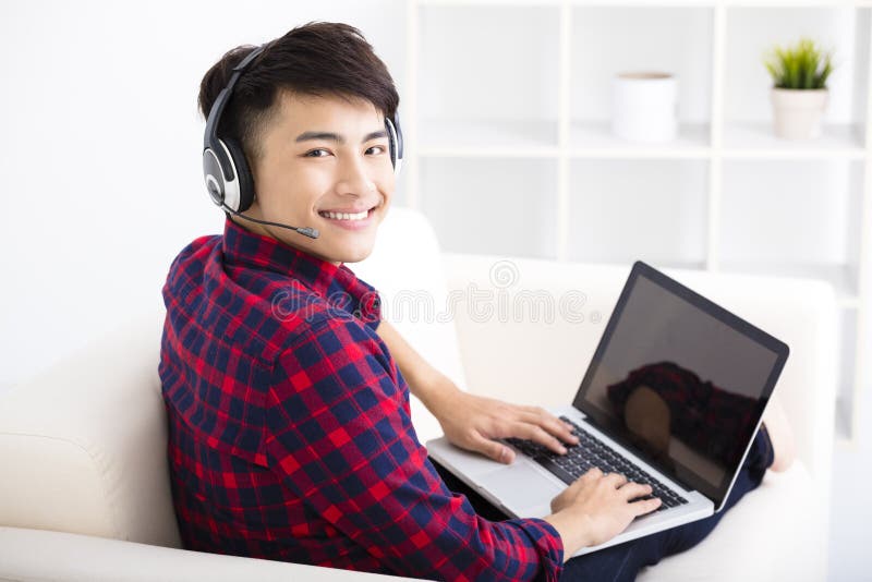 Young Man Using Laptop Computer with Headset Stock Photo - Image of ...