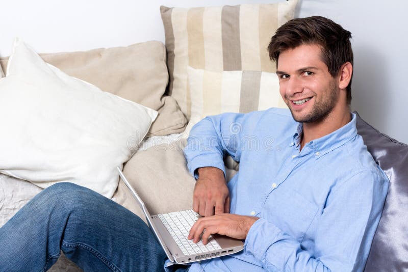 Young Man Using Laptop on Couch Stock Image - Image of male, lifestyle ...