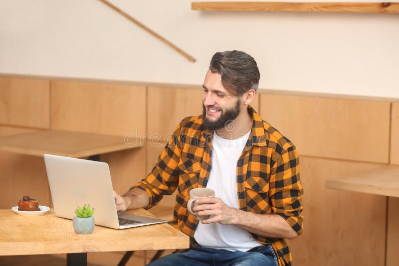 Young Man Using Laptop while Drinking Tea in Cafe Stock Image - Image ...