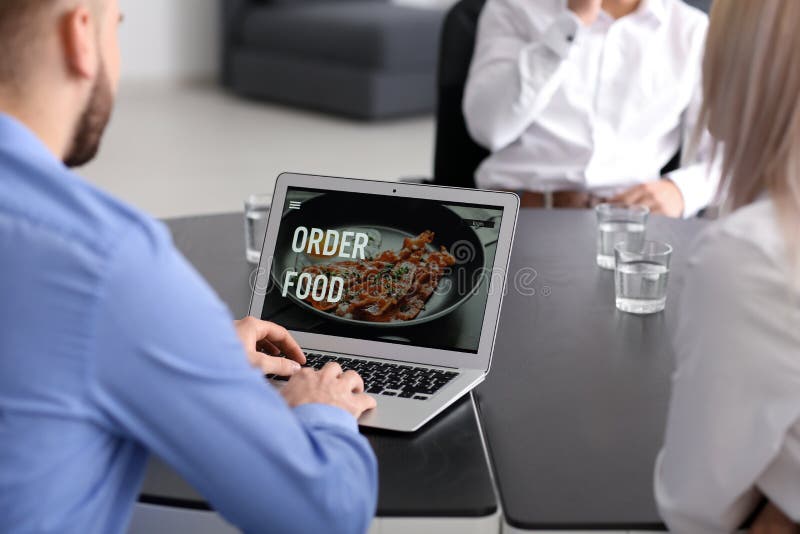 Young Man Using Laptop for Ordering Food in Office Stock Image - Image ...