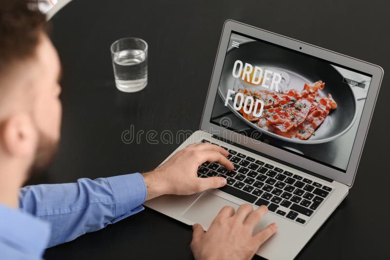 Young Man Using Laptop for Ordering Food in Office Stock Image - Image ...
