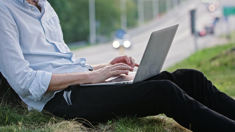 A Young Man Using a Laptop Outdoors Stock Image - Image of meadow ...