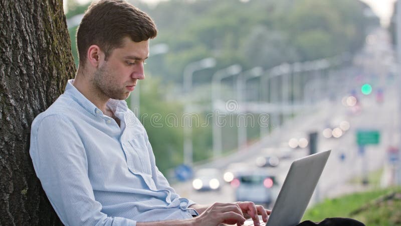 A Young Man Using a Laptop Outdoors Stock Photo - Image of relax ...