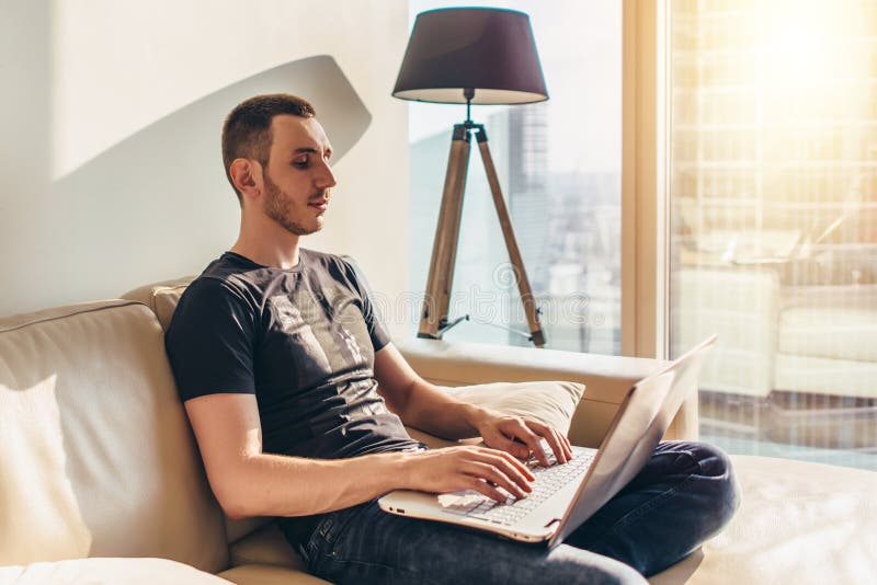 Young Man Using Laptop while Sitting on a Sofa Stock Image - Image of ...