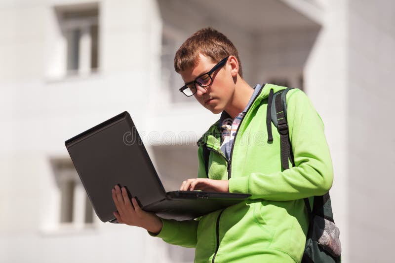 Young Man Using Laptop Walking in City Street Stock Photo - Image of ...