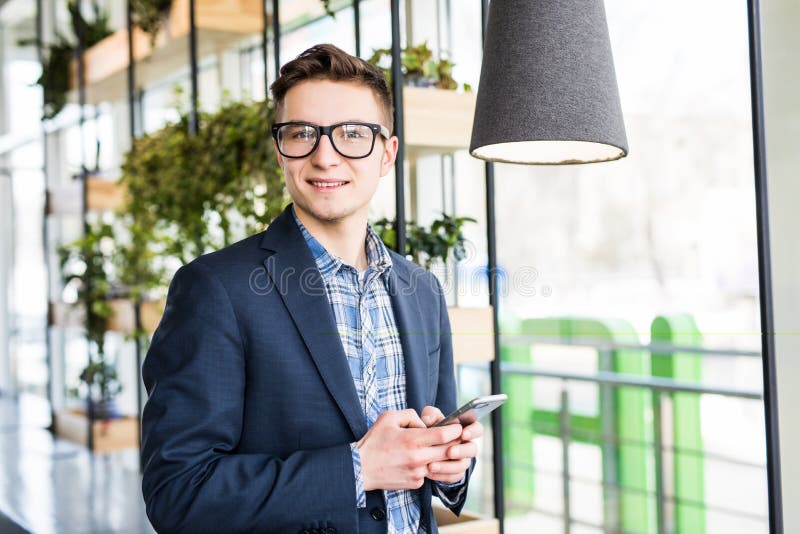 Young Man Using Mobile Phone at Office Windows Stock Photo - Image of ...