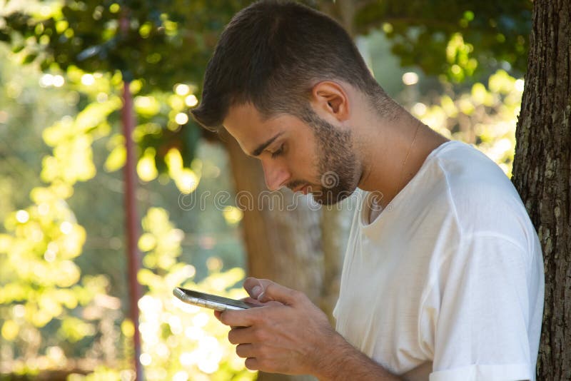 Man Looking at Mobile Phone or Typing, Profile View Outdoors Stock ...