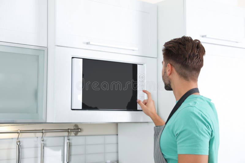 Young Man Using Modern Microwave Oven Stock Image - Image of heat ...