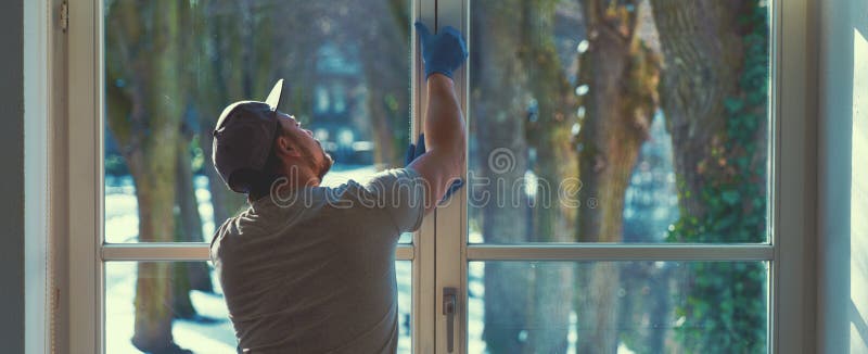 Young Man is Using a Rag and Squeegee while Cleaning Windows. Stock ...