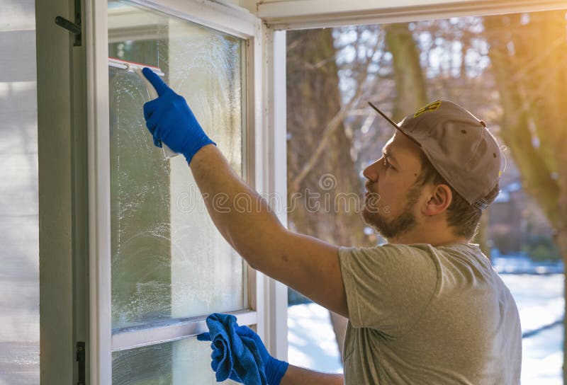 Young Man is Using a Rag and Squeegee while Cleaning Windows. Stock ...