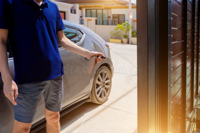 Young Man Using Remote Control To Open Automatic Sliding Front Gate at ...