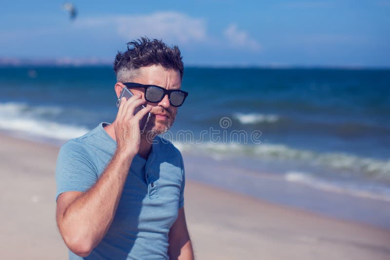 Young Man Using Smartphone on the Beach Stock Photo - Image of cell ...