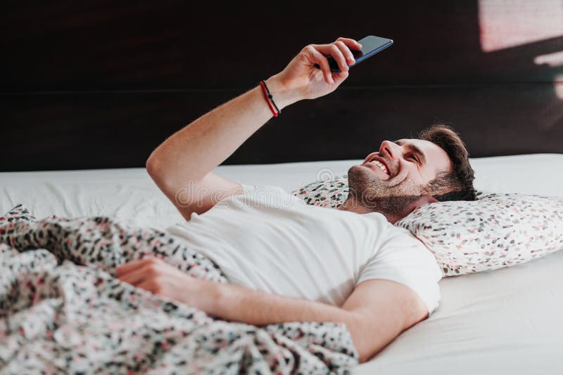 Young Man Using Smartphone in Bed Stock Image - Image of gadget, people ... Young Man Using Smartphone in Bed Stock Image - Image of gadget, people ...