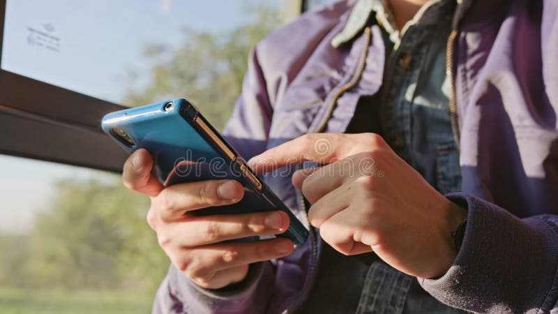 A Young Man Using a Smartphone on the Bus Stock Photo - Image of purple ...