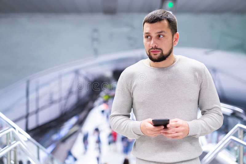 Young Man Using Smartphone To Check Schedule on Subway Station Stock ...